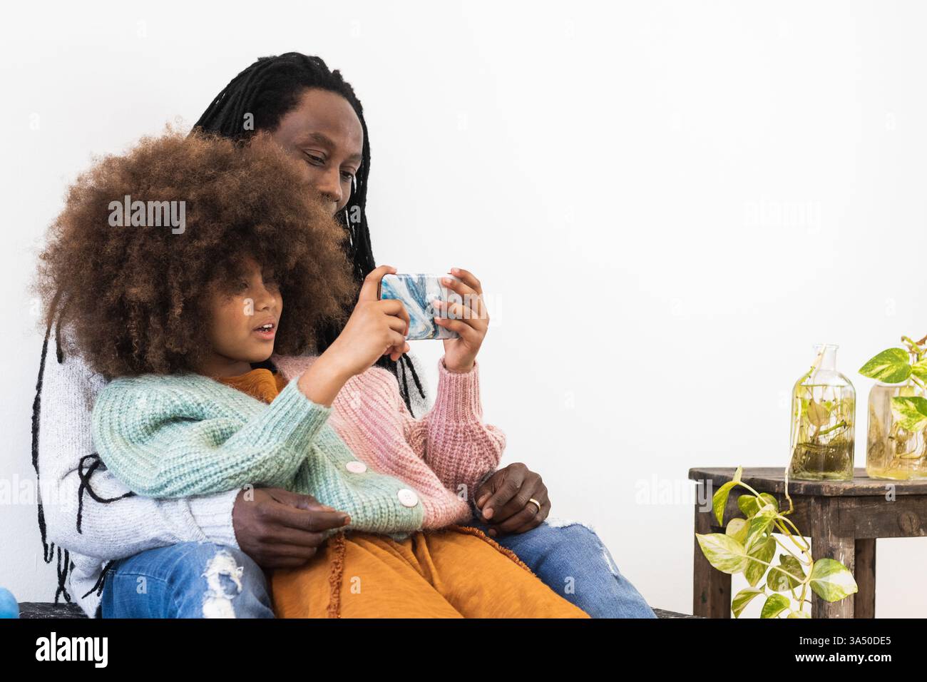 Black father with locks hugging Mixed race daughter with afro while ...