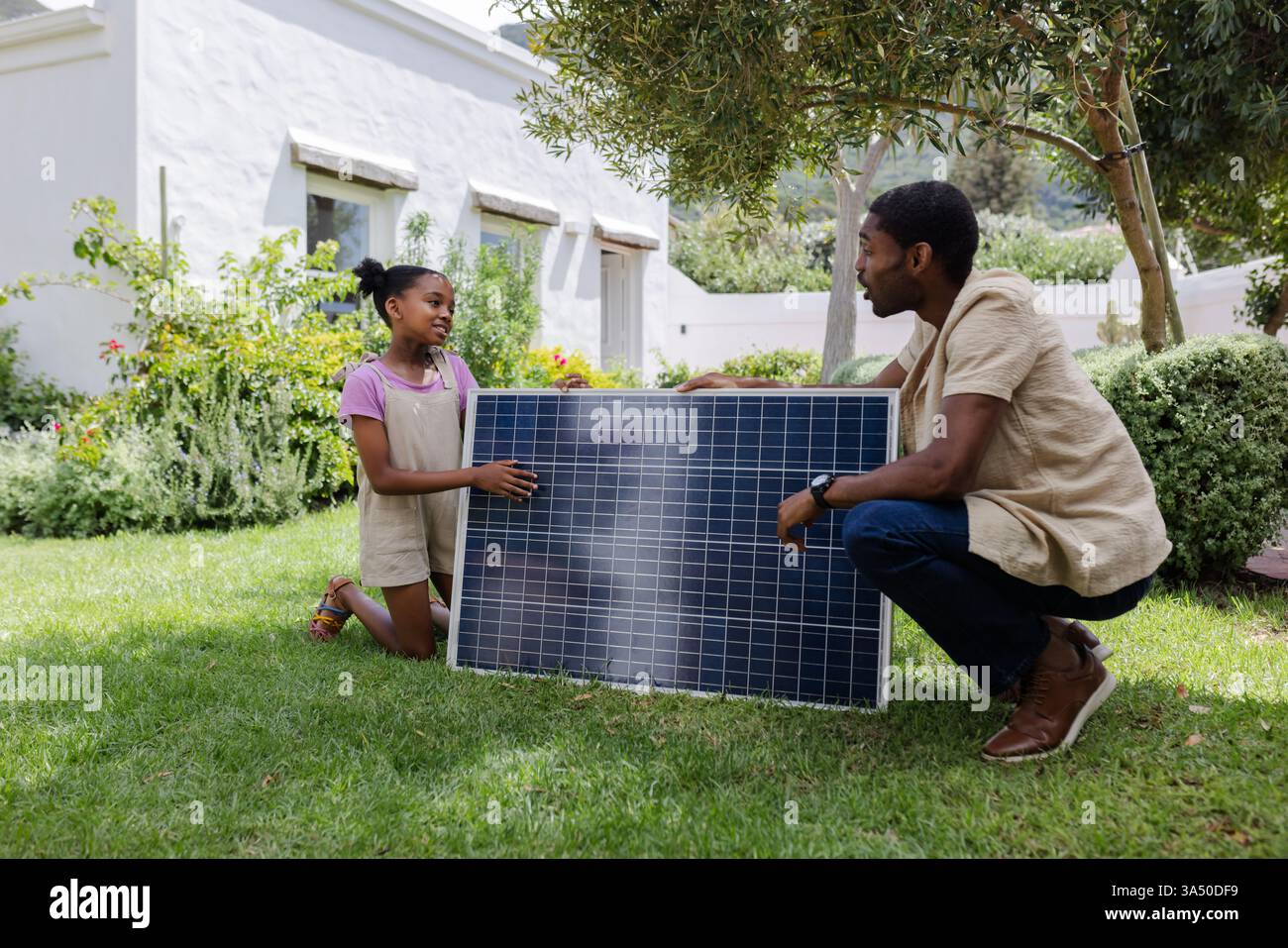 Installing solar panel in garden, father and daughter learning ...