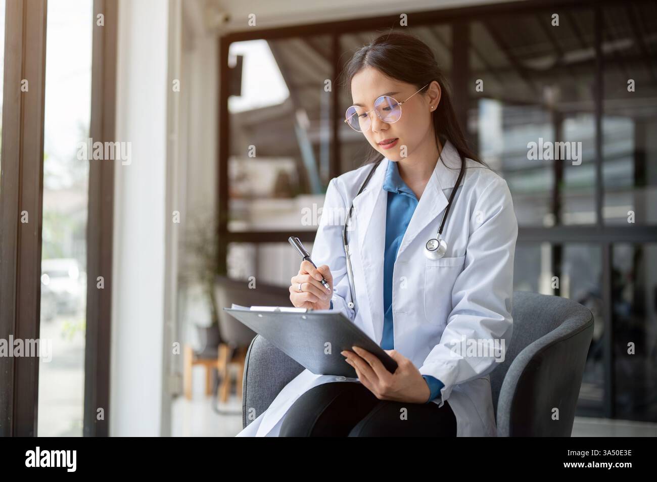 A professional and experienced Asian female doctor is reading and ...