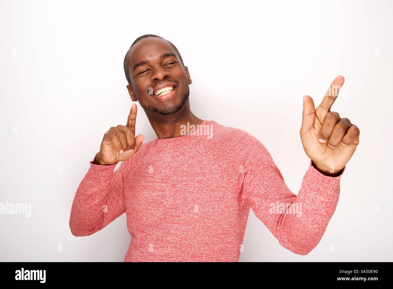 Cheerful Black male pointing fingers dancing against white background ...