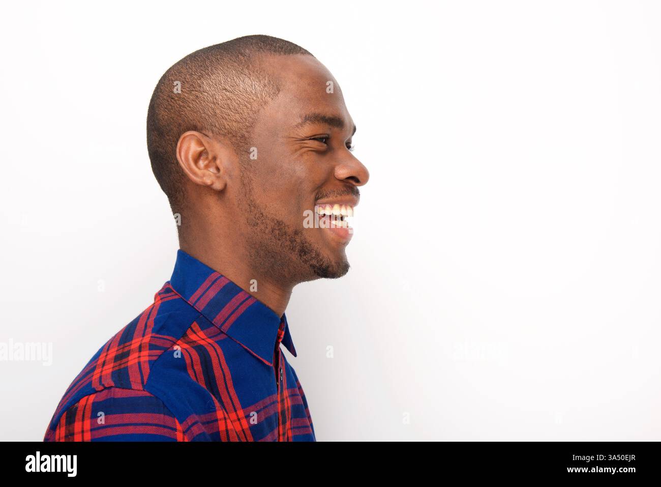 Smiling Black male standing sideways against white background Stock ...