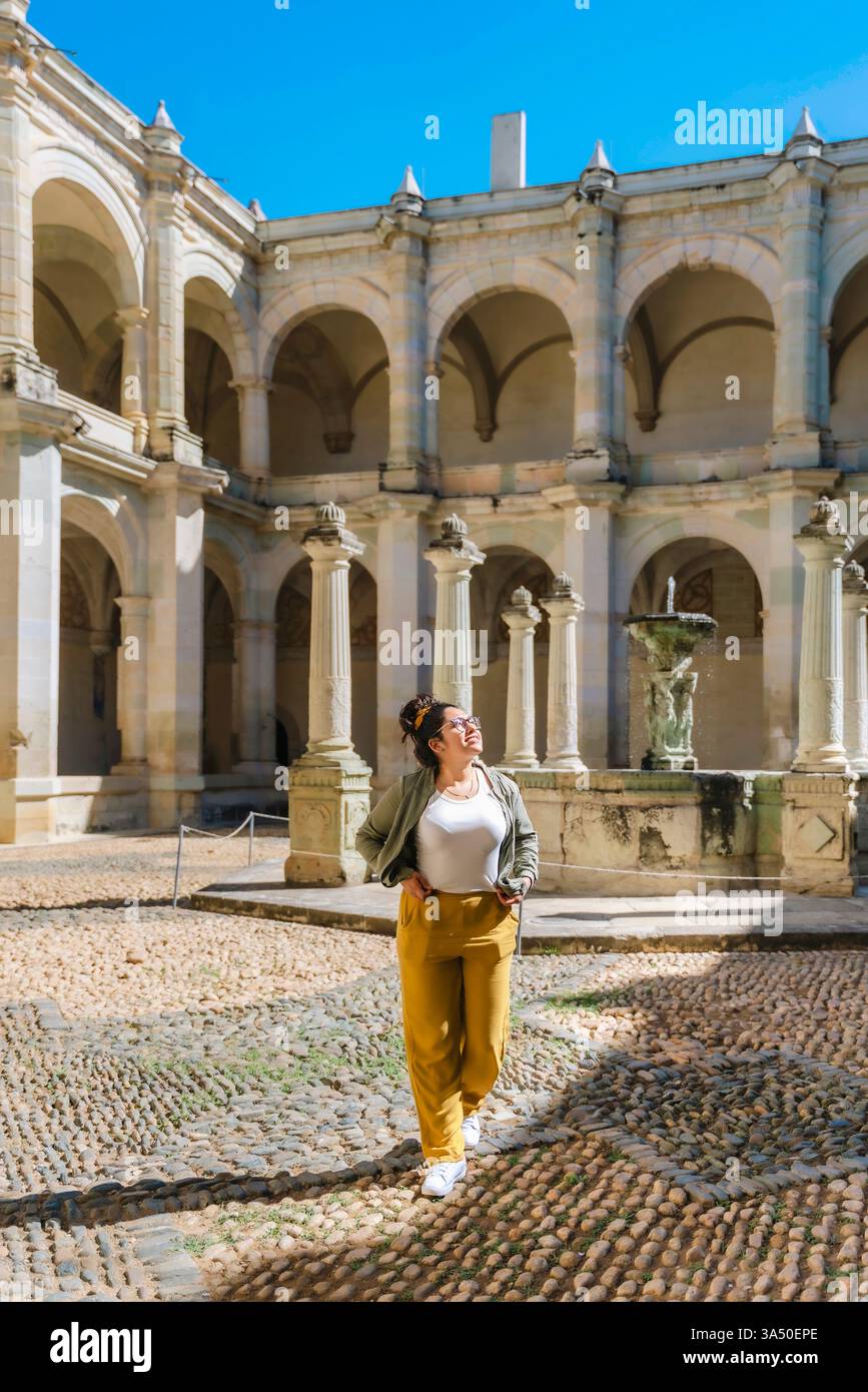 Hispanic female tourist walking and admiring the courtyard of historic ...