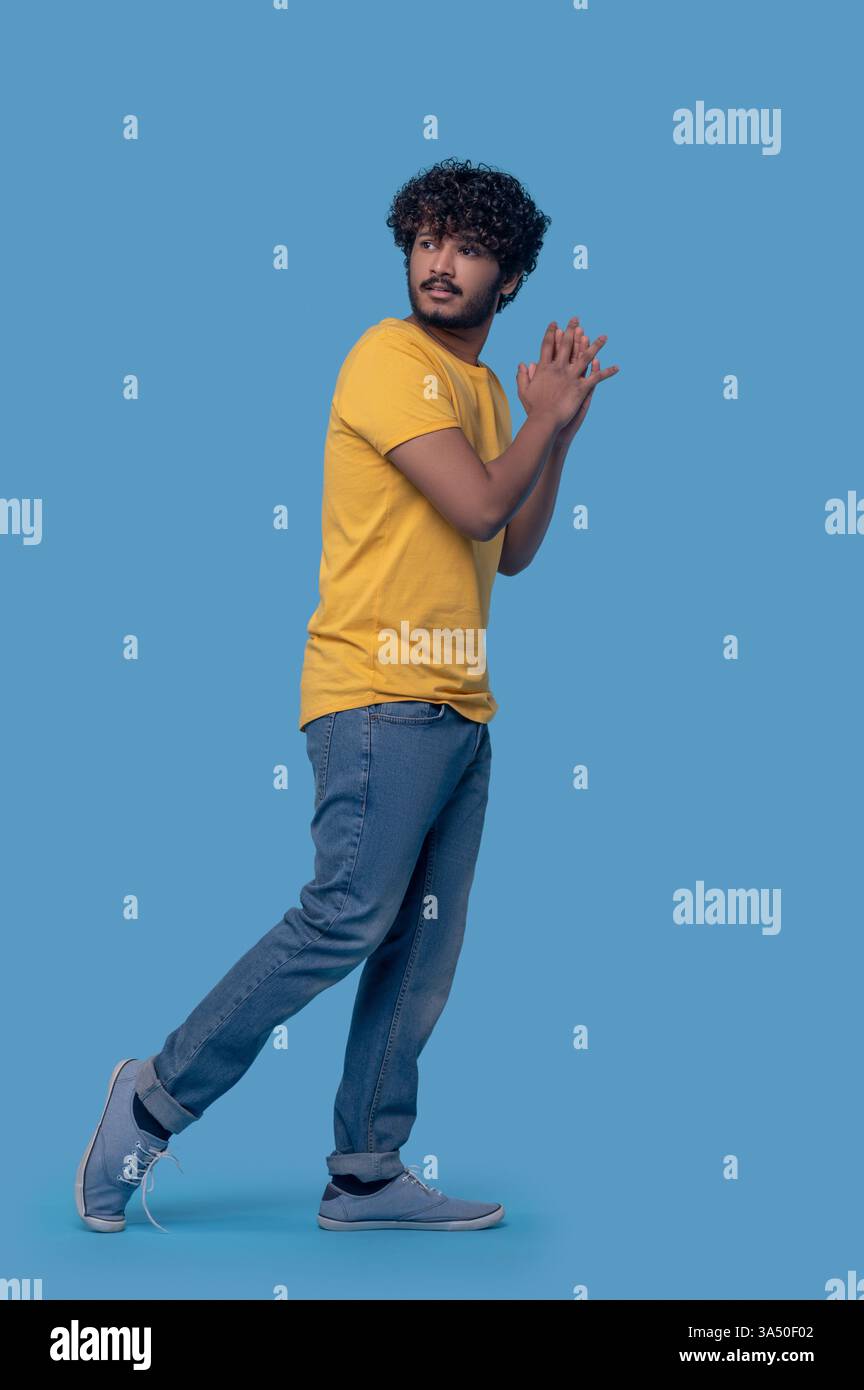 Serious Indian man with curly hair looking over shoulder standing ...