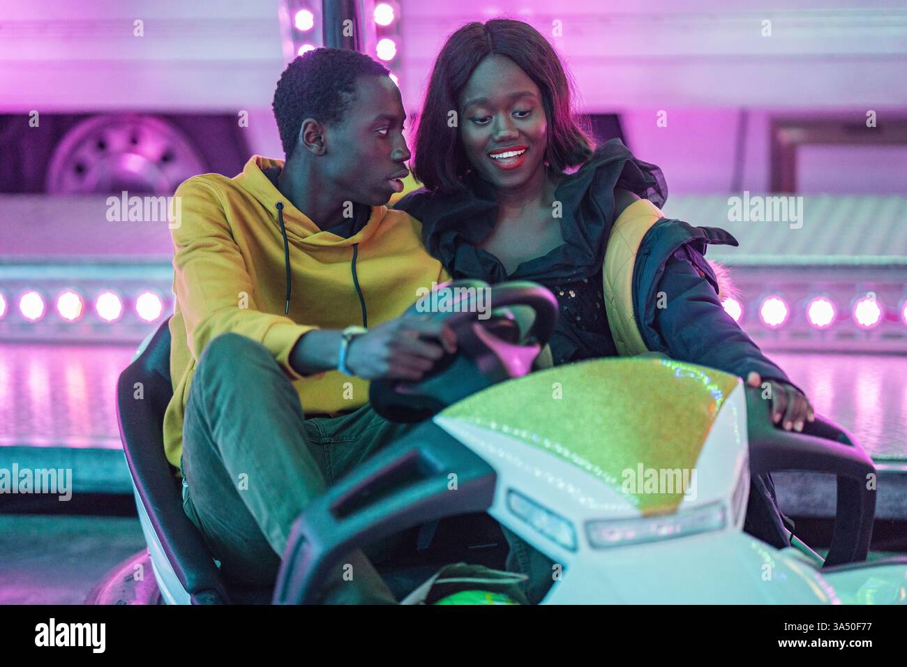 Black couple riding bumper car at amusement park arcade Stock Photo - Alamy