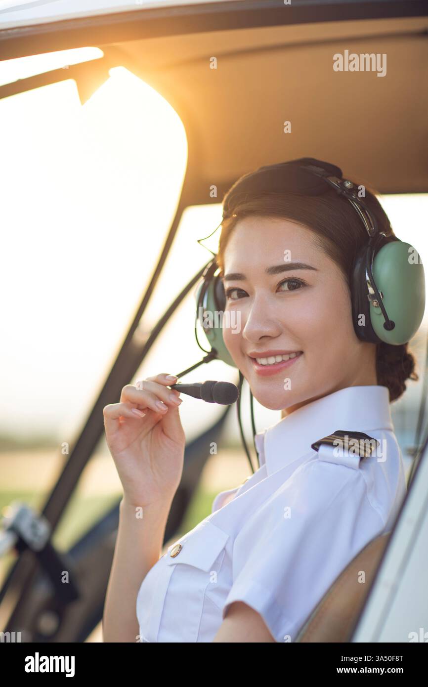 Chinese female pilot in the cockpit of a helicopter. Portrait style ...