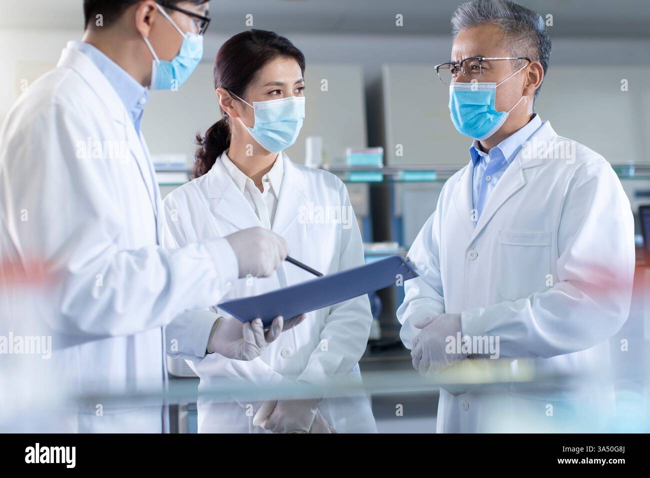 Three Chinese researchers discussing in laboratory Stock Photo - Alamy