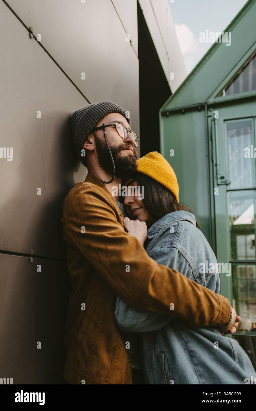 Hispanic couple sharing a tender moment indoors on a sunlit veranda ...