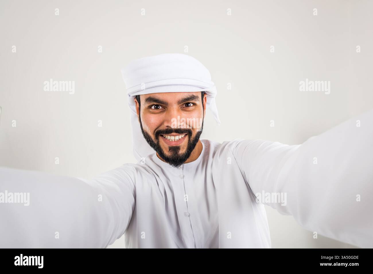 Middle Eastern man in traditional Emirati kandura posing in a ...