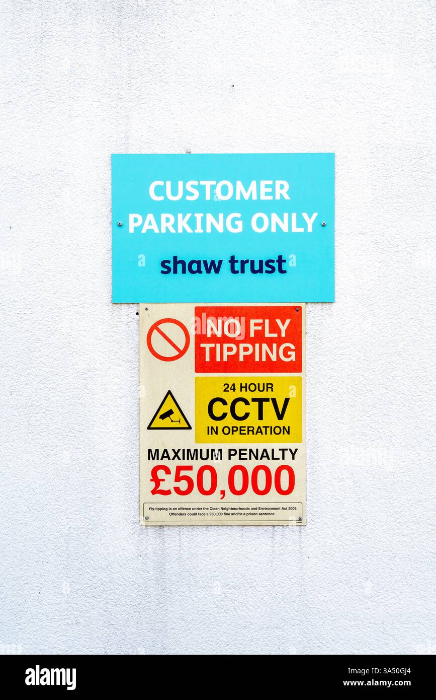 Customer parking only sign and warning of penalty fine for fly tipping ...