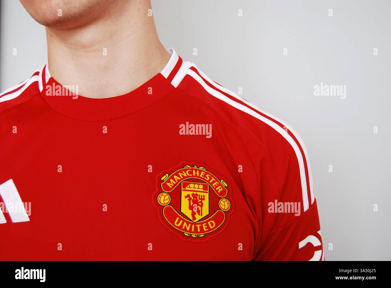 Photo of model wearing Manchester United FC home kit with club badge ...