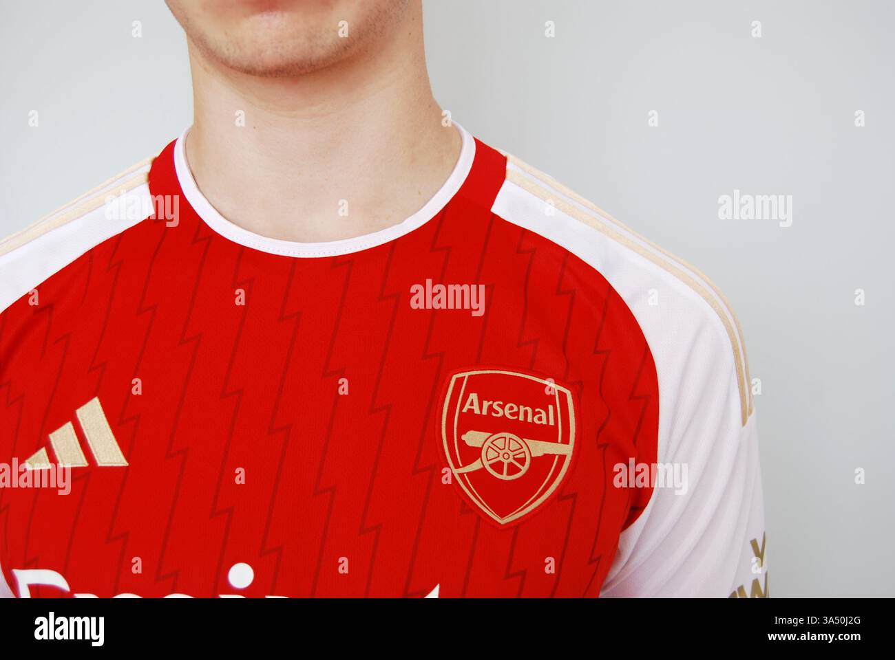 Photo of model wearing Arsenal FC home kit with club badge Stock Photo ...