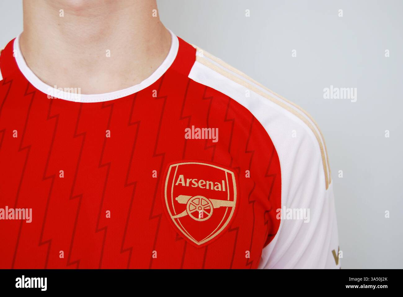 Photo of model wearing Arsenal FC home kit with club badge Stock Photo ...