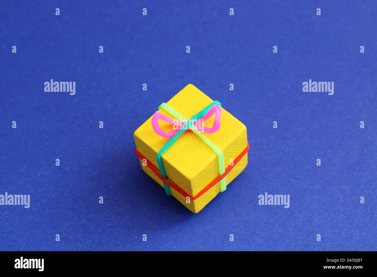 Gift box formed with a cube and colorful rubber bands Stock Photo - Alamy