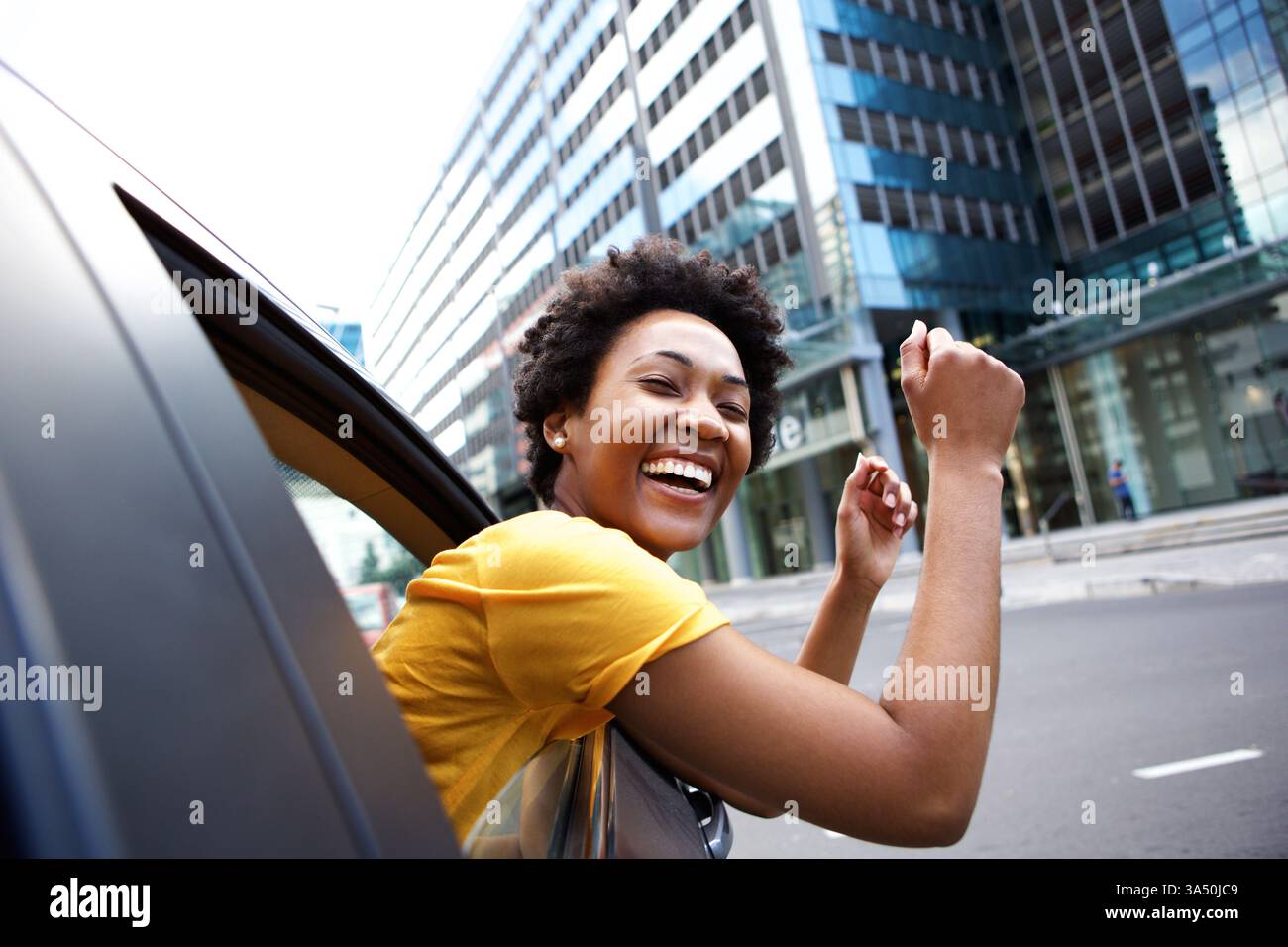 Portrait of cheerful young african woman looking out the car window ...