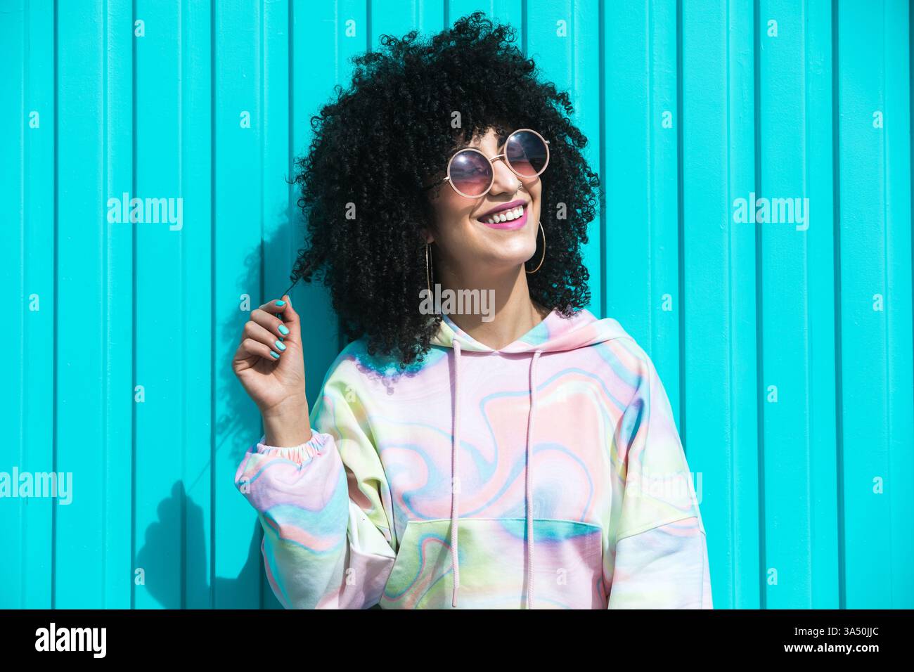 Positive young Hispanic female with Afro hairstyle and sunglasses ...