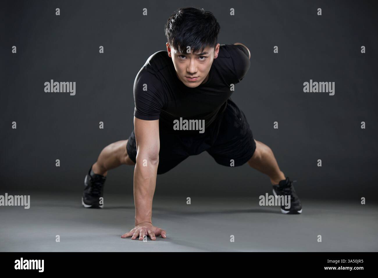 Young Chinese man performing one handed push ups, showcasing strength ...