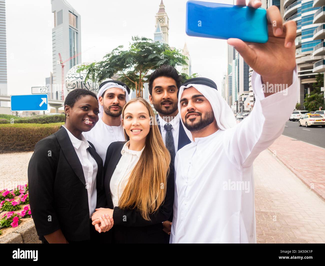 Diverse group of business professionals in the UAE walking outdoors and ...