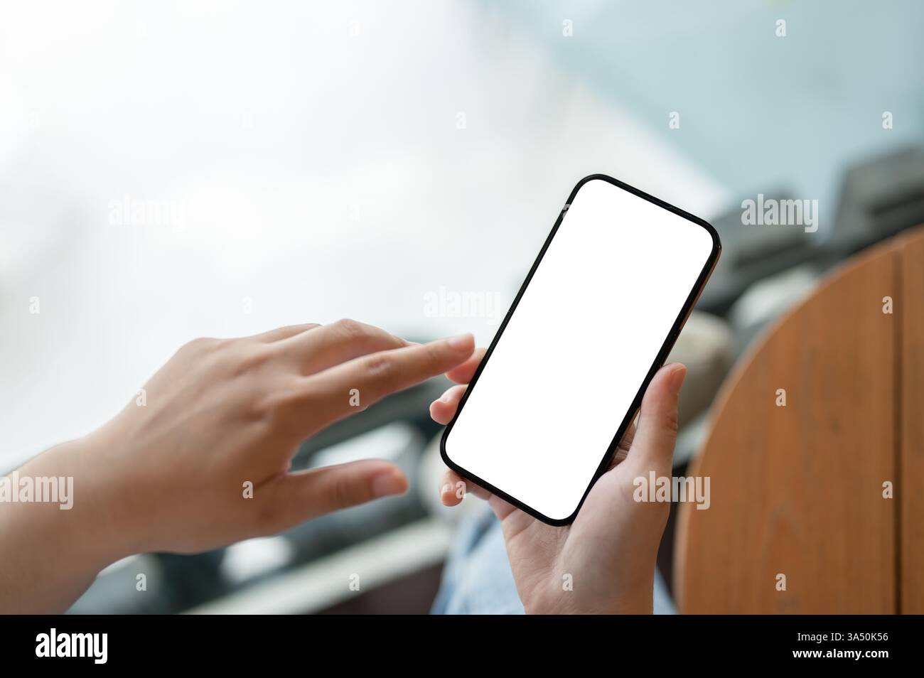Top view of a female holding a smartphone white screen mockup over a ...