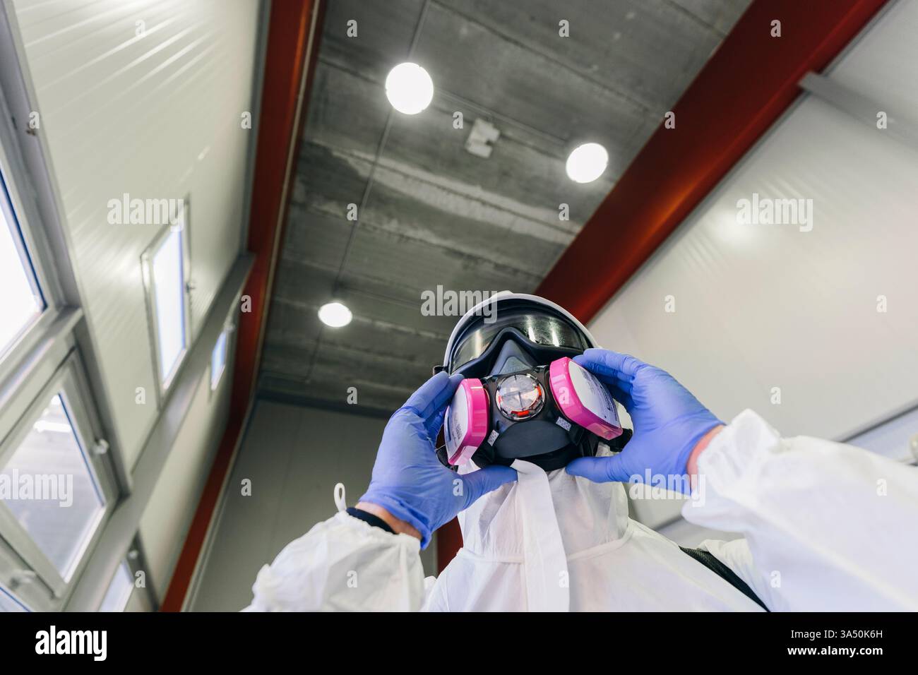 Hispanic male firefighter in white ppe and safety helmet adjusting air ...