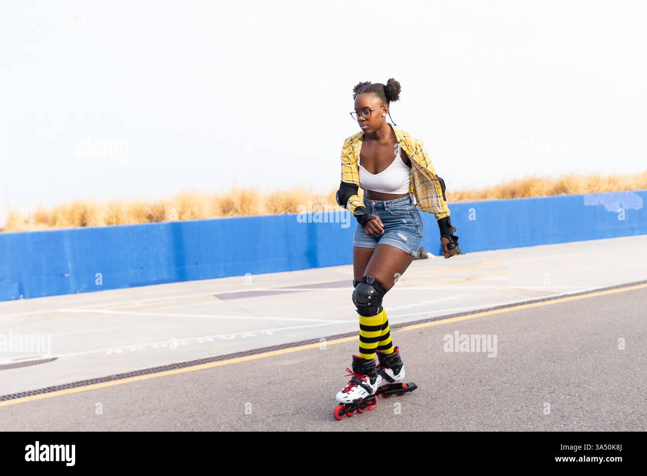 Full body of young African American woman rollerskating on rink at ...