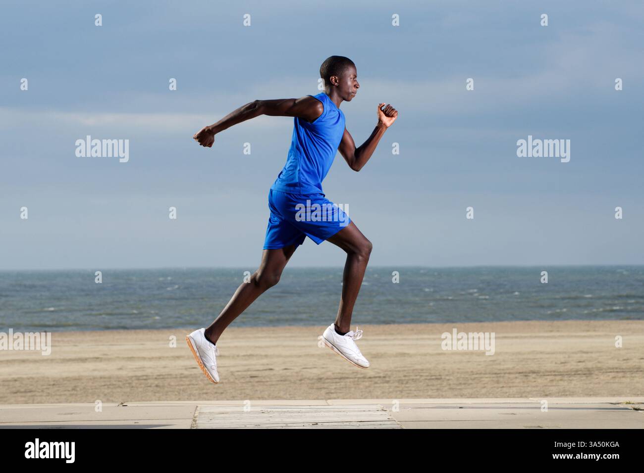 Full length side portrait of fit young african man running along the ...