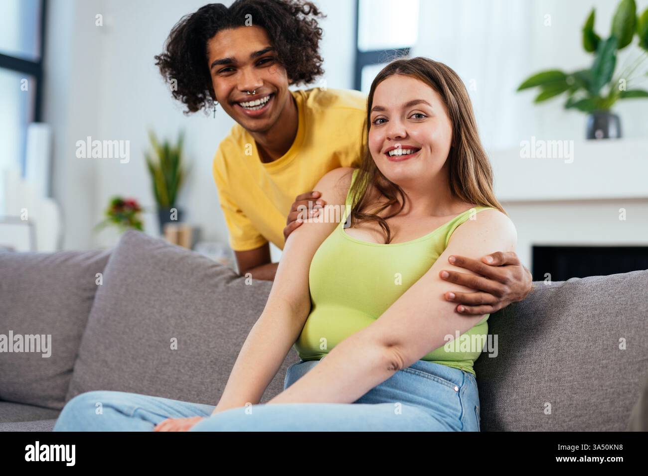 Cheerful Black man with curly hair standing and leaning forward behind ...