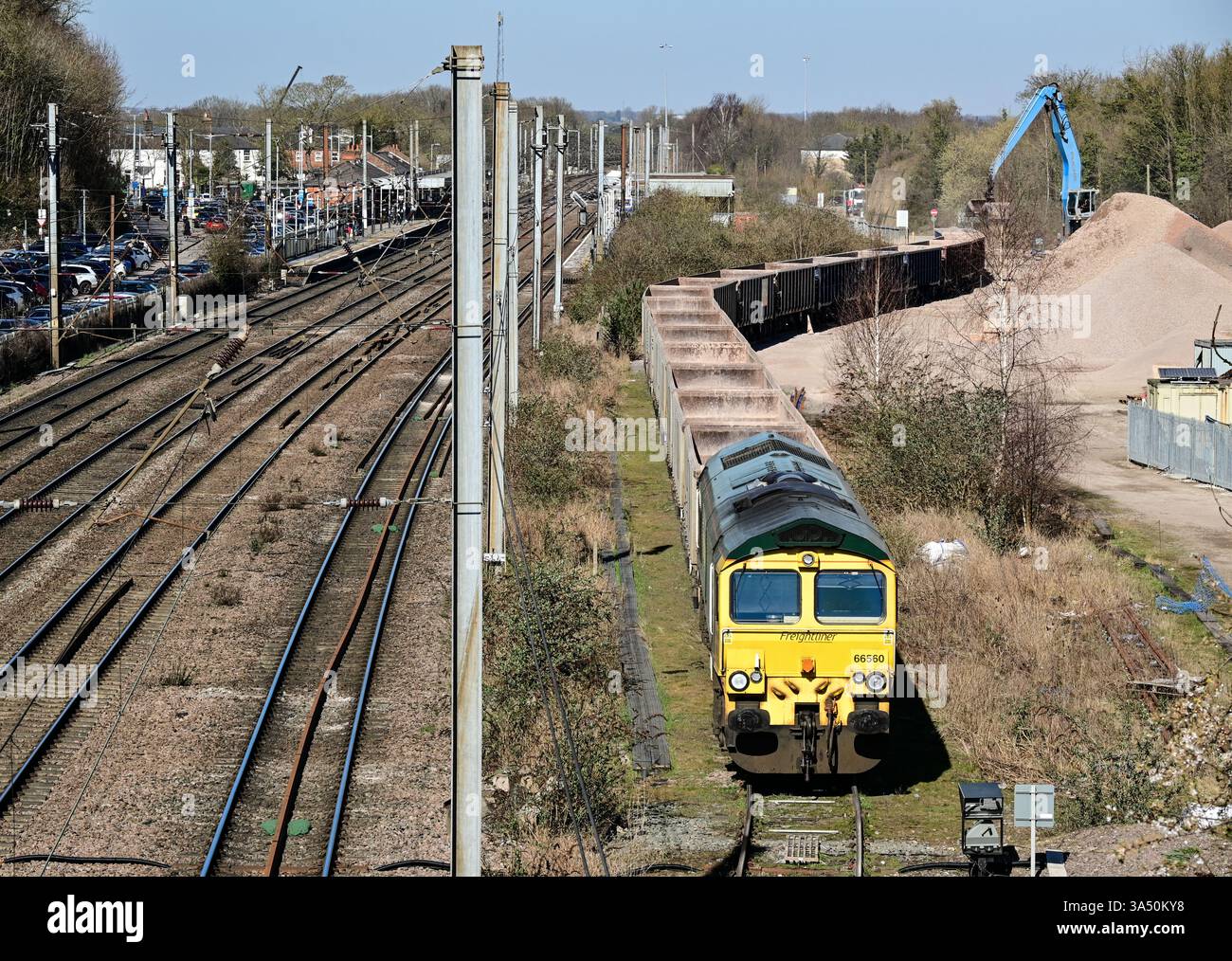 Class 66 diesel with wagons of aggregate being unloaded in the yard at ...