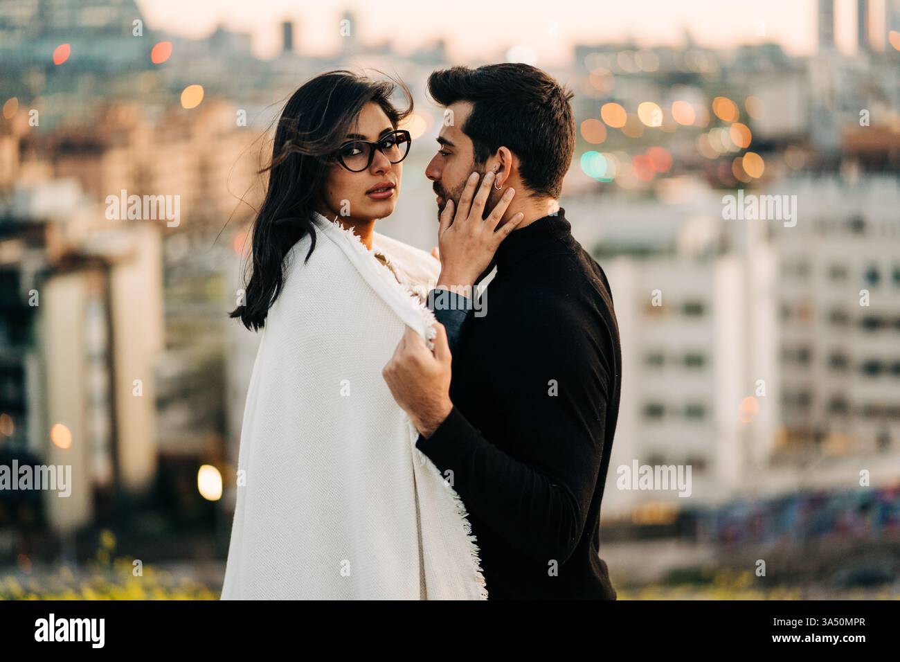 Side view of man embracing female beloved in eyeglasses with plaid in ...