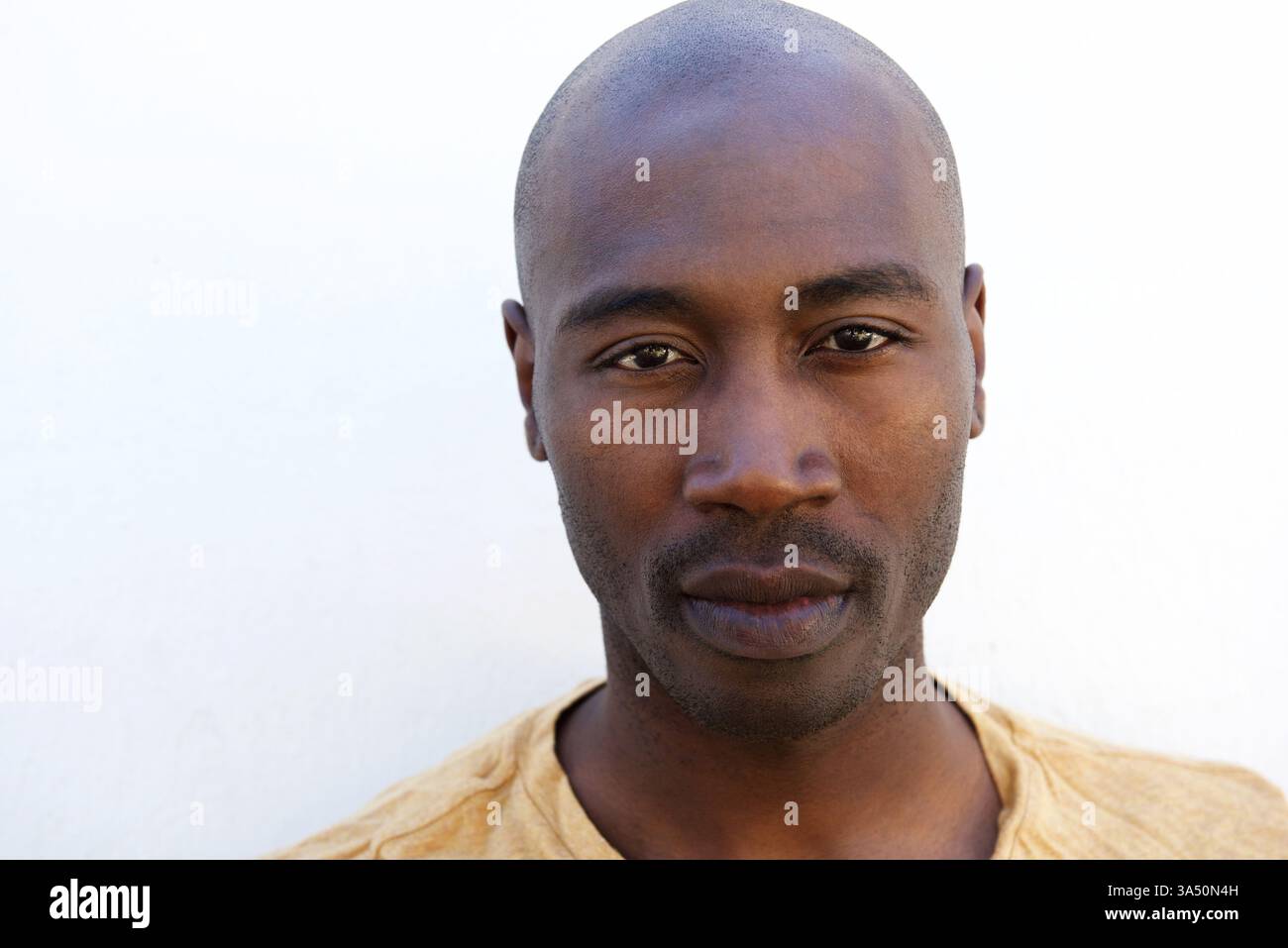 Serious Black man standing against white background Stock Photo - Alamy