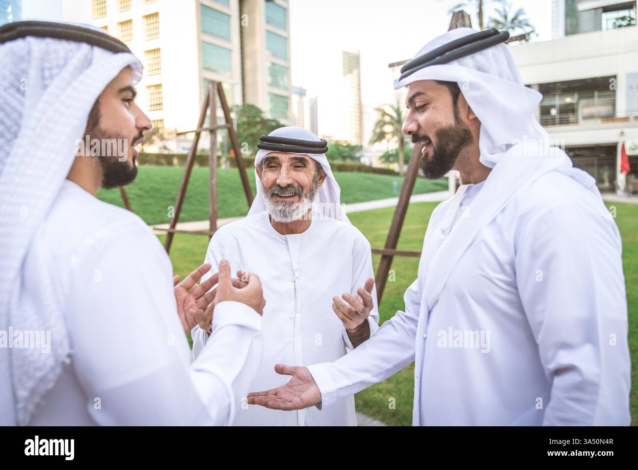 Three business men walking in Dubai wearing traditional Emirati ...