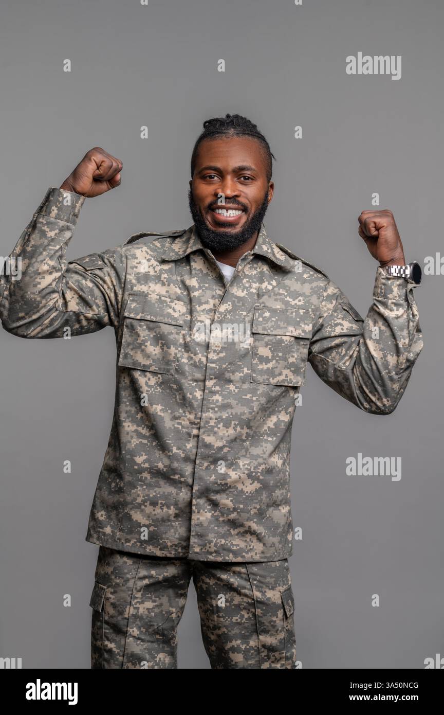 Front view of a cheerful military man in uniform posing for the camera ...