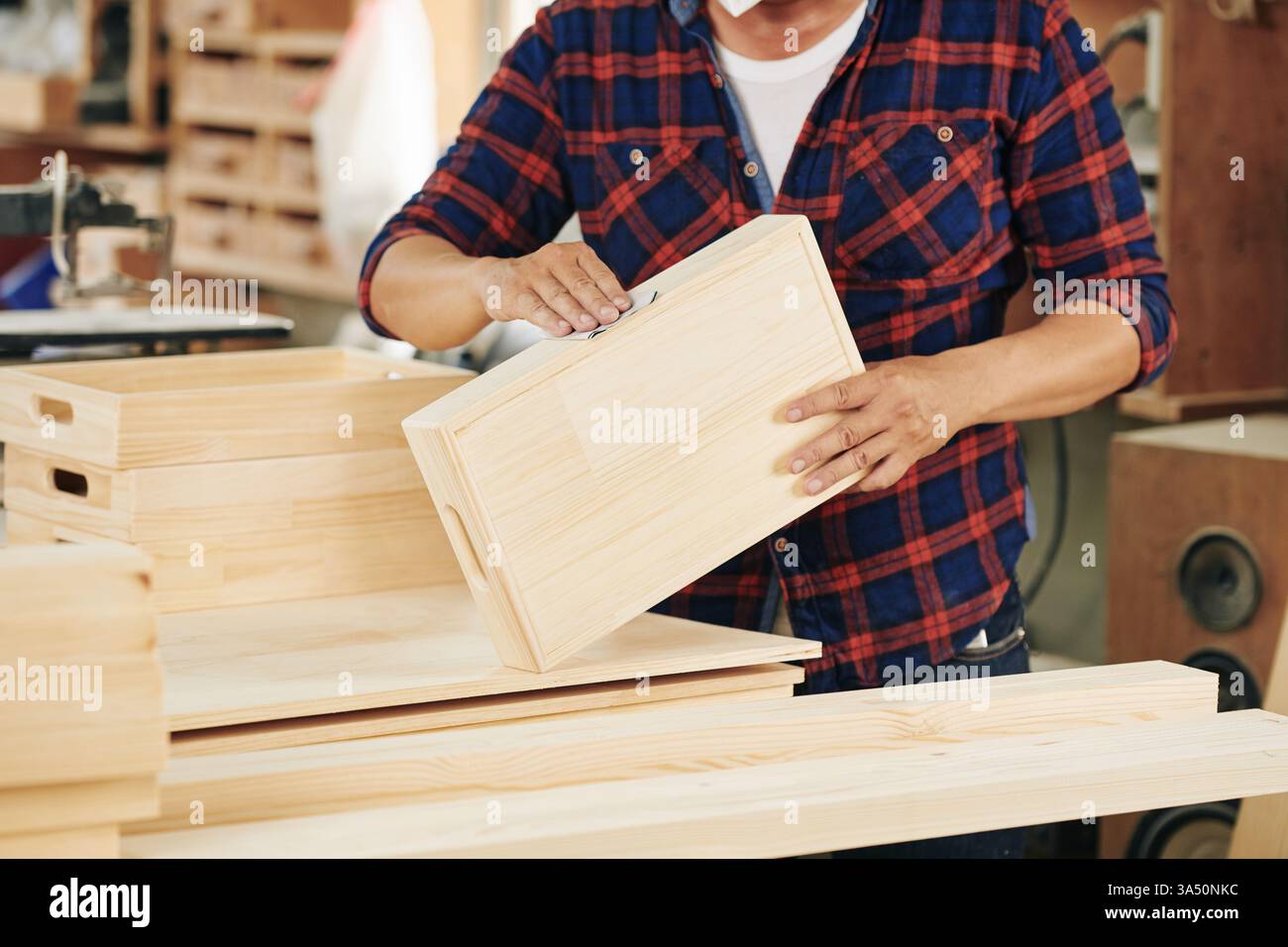 Cropped image of carpenter sanding wooden drawer he made for customer ...