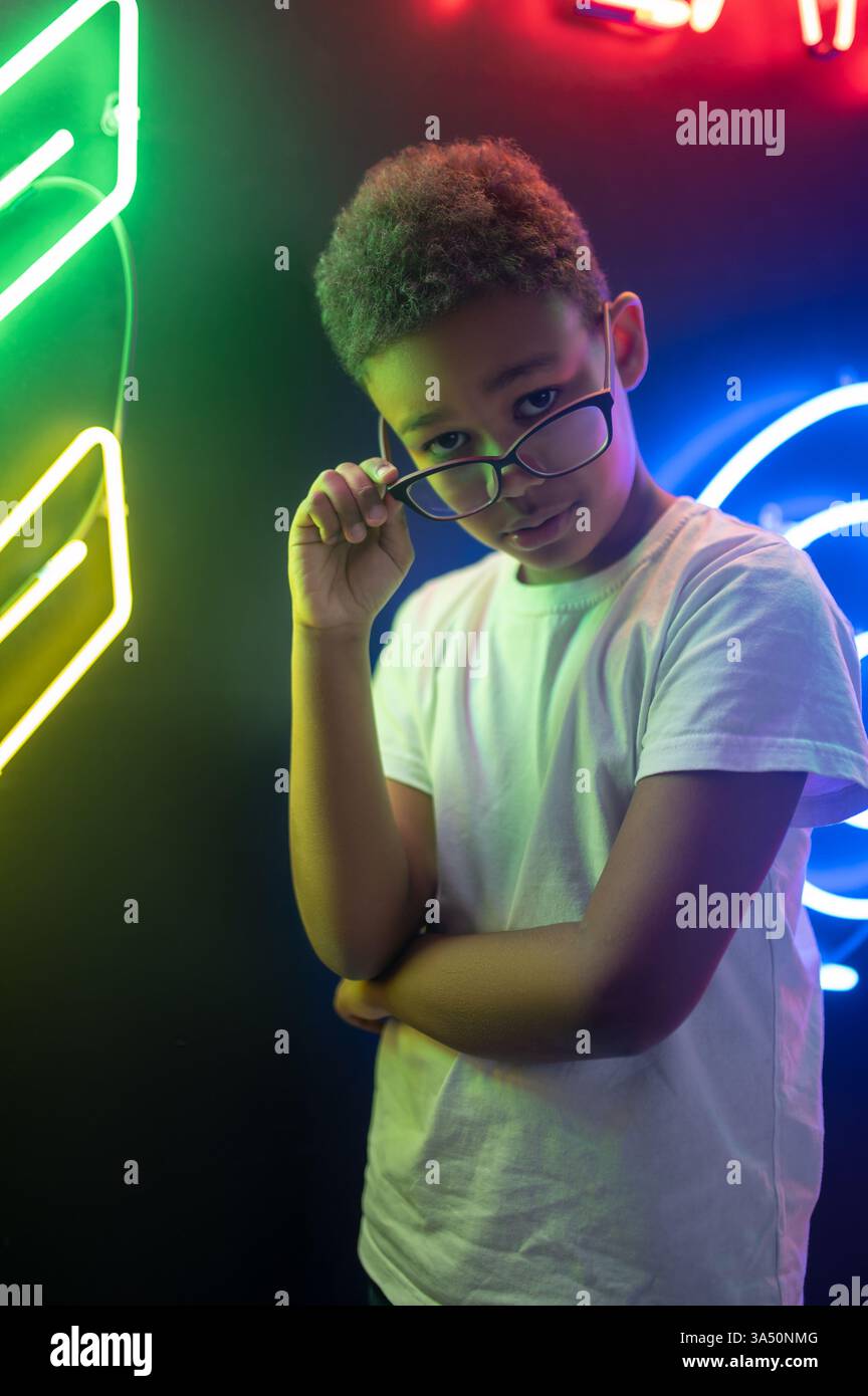 Calm confident cute African American teenager in spectacles standing in ...