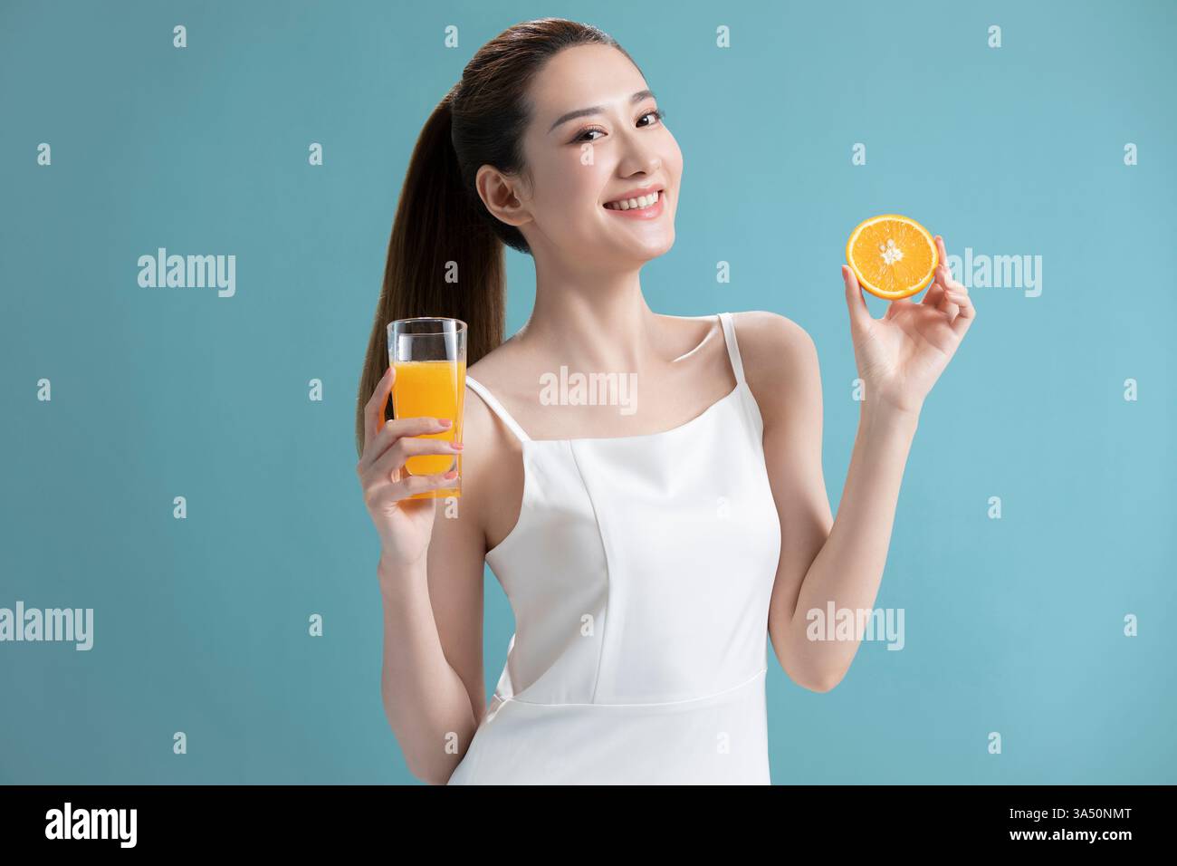 Beautiful young Chinese woman drinking orange juice Stock Photo - Alamy