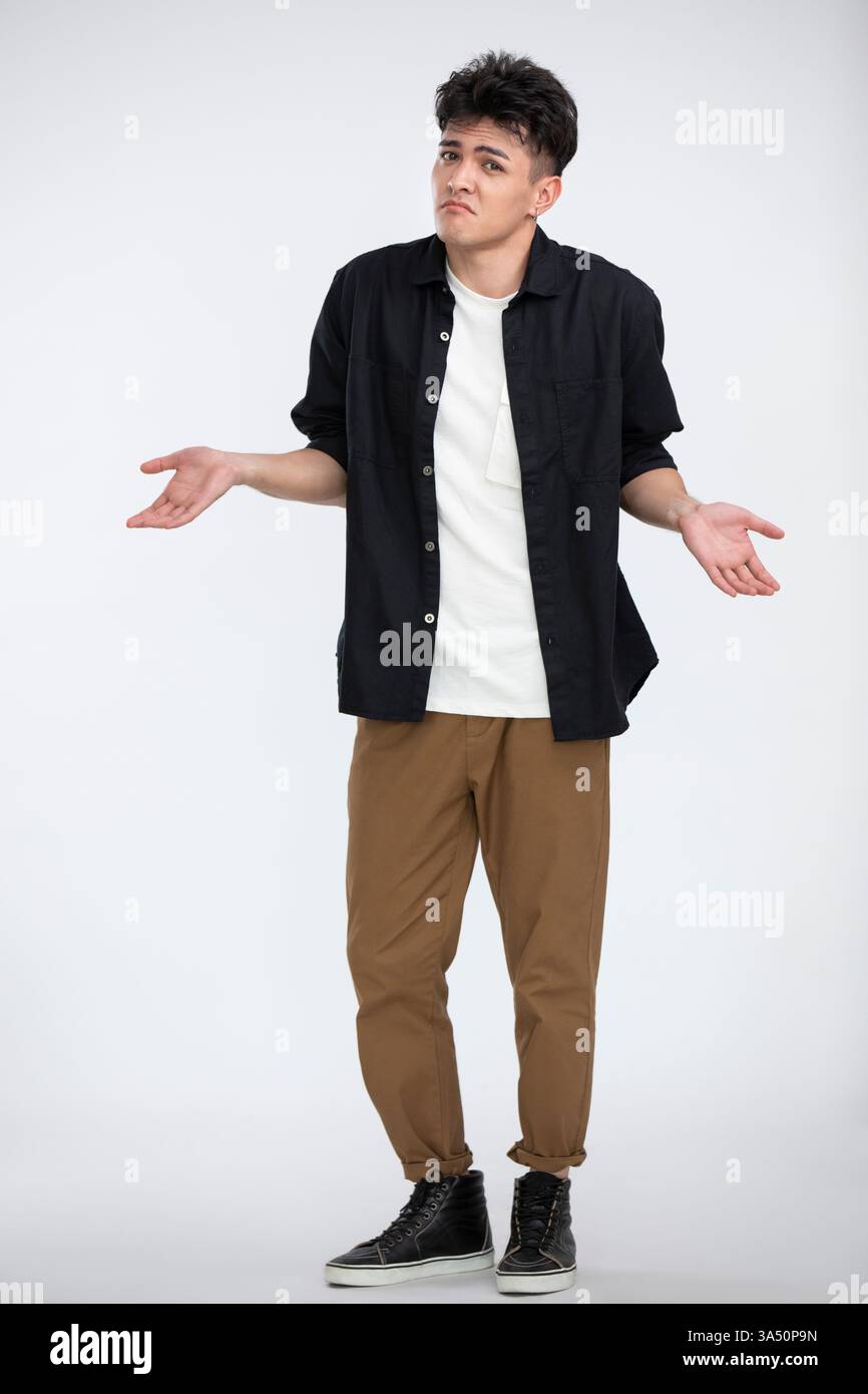 Serious Chinese man with open hands shrugging his shoulders standing ...