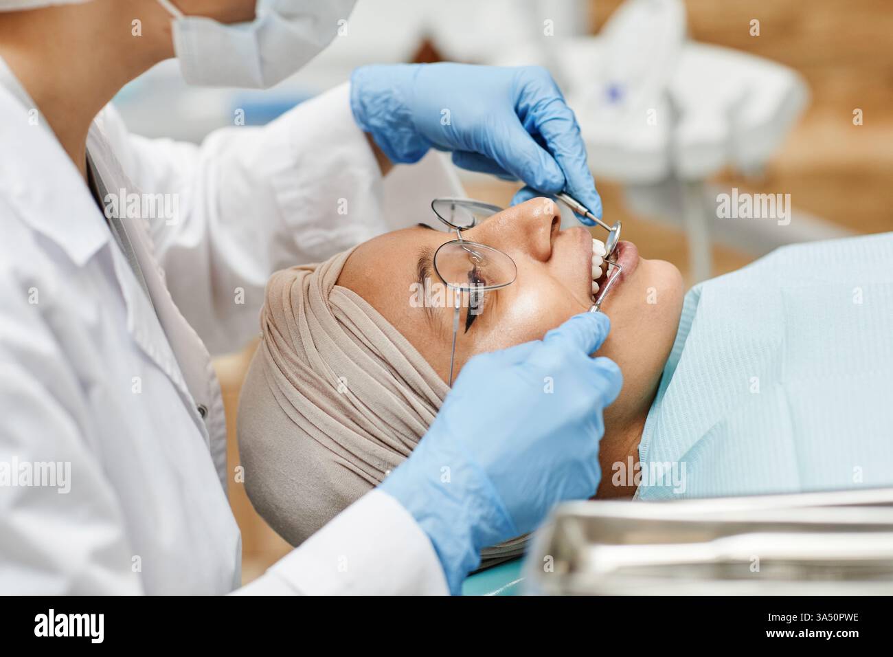 Side view portrait of Arab young woman laying in dental chair with ...