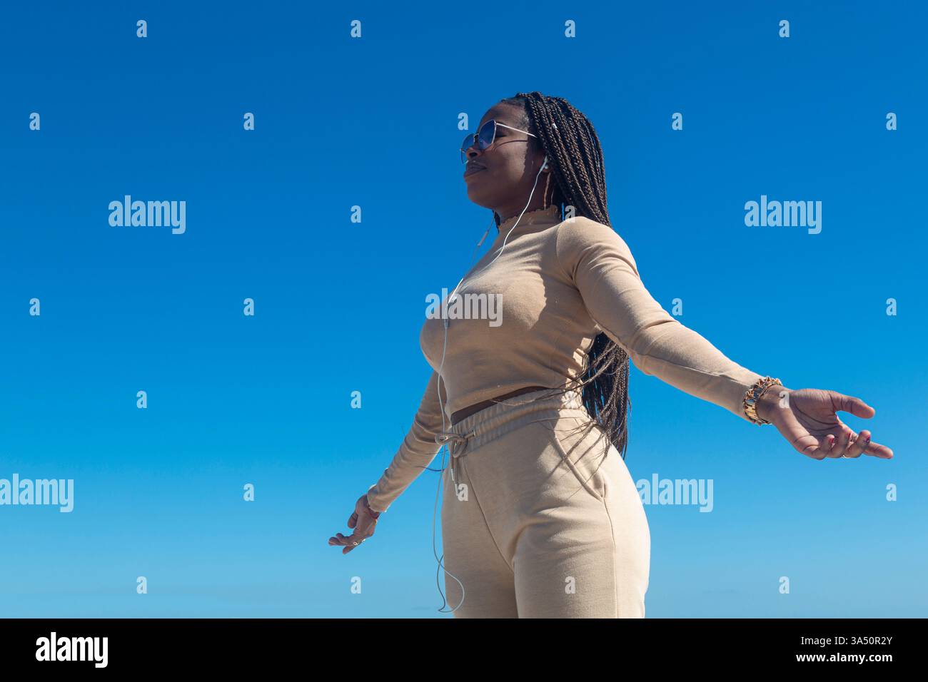 African American woman with open arms in a bright outdoor setting ...