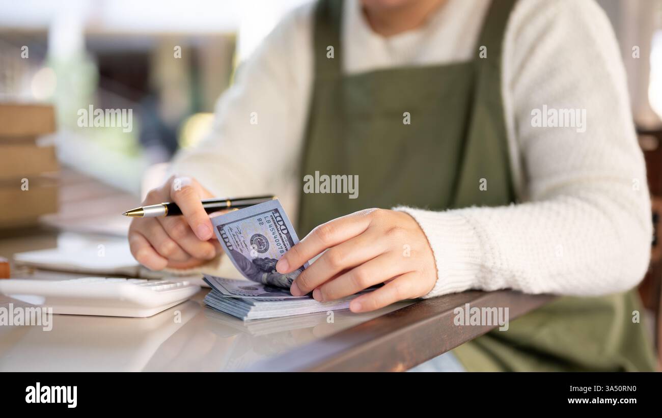 A cropped shot of a female small business owner managing her shop ...