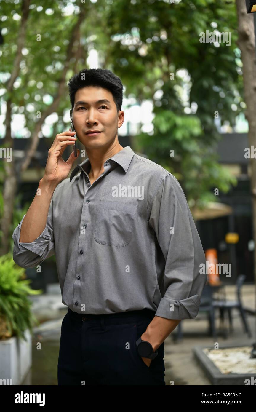 Portrait of a handsome millennial Asian man or businessman is talking ...
