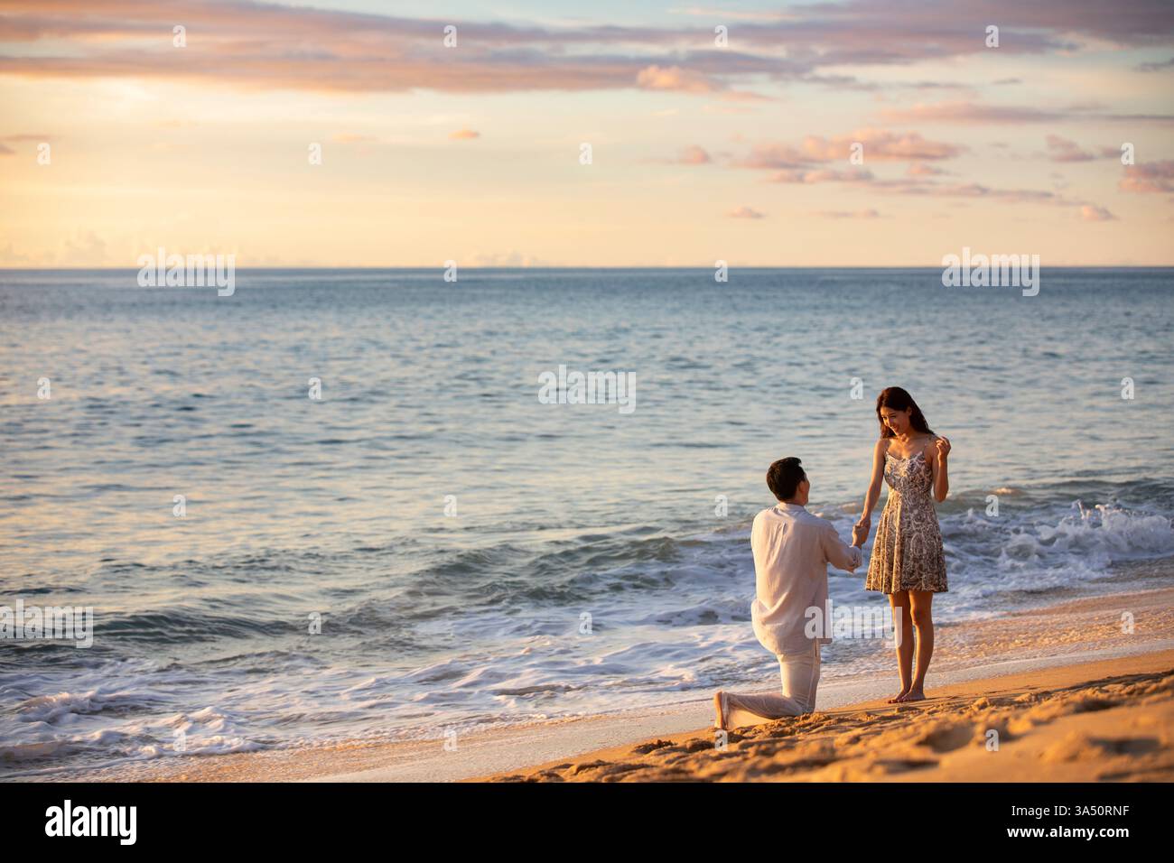 Chinese man kneeling with one leg while holding her partner's hand on ...
