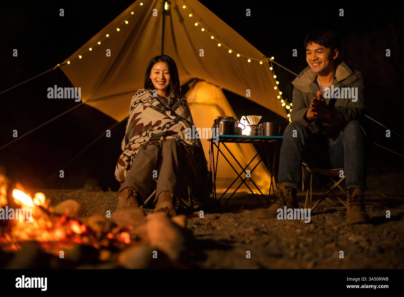 Happy young Chinese couple camping outdoors Stock Photo - Alamy