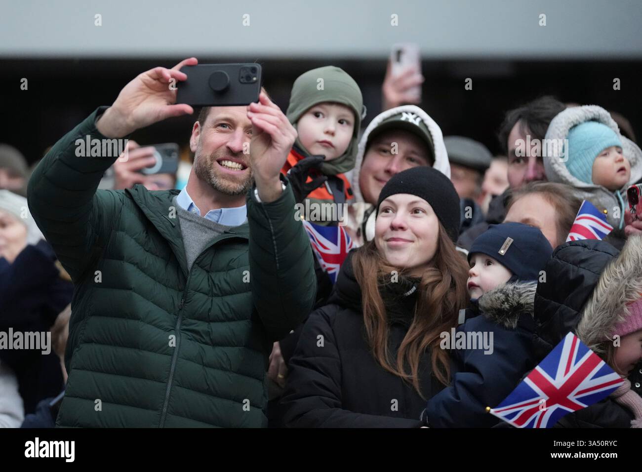 Britain's Prince William poses for a selfie as he walks in a street ...