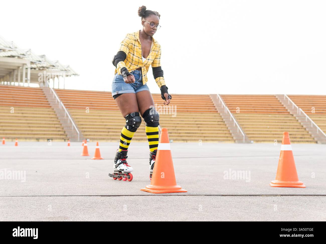 Full body of determined young African American woman rollerskating by ...