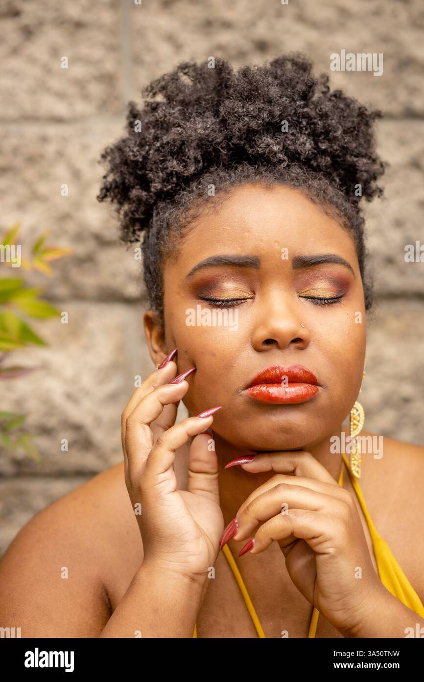 Plus size black woman touching face Stock Photo - Alamy