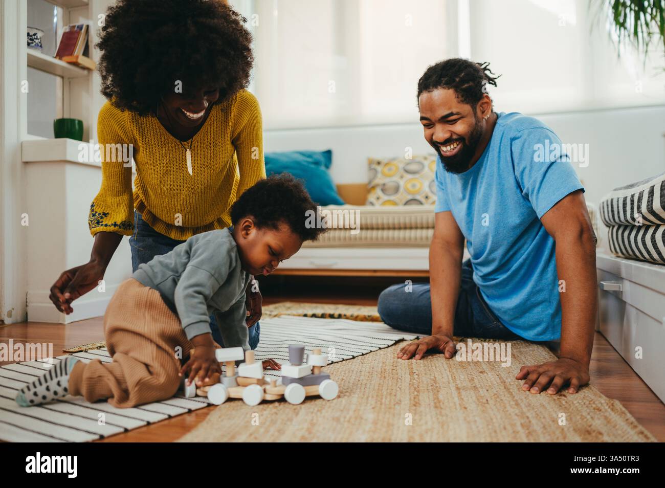 An african american family having fun at home at playday. An african american toddler is playing ...
