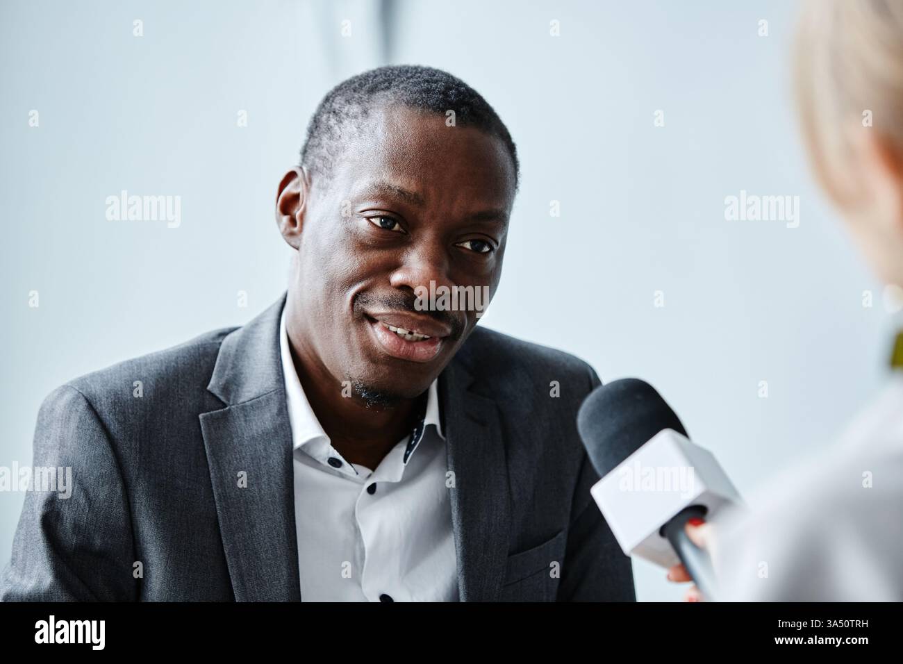 Portrait of a successful Black businessman speaking into a microphone ...