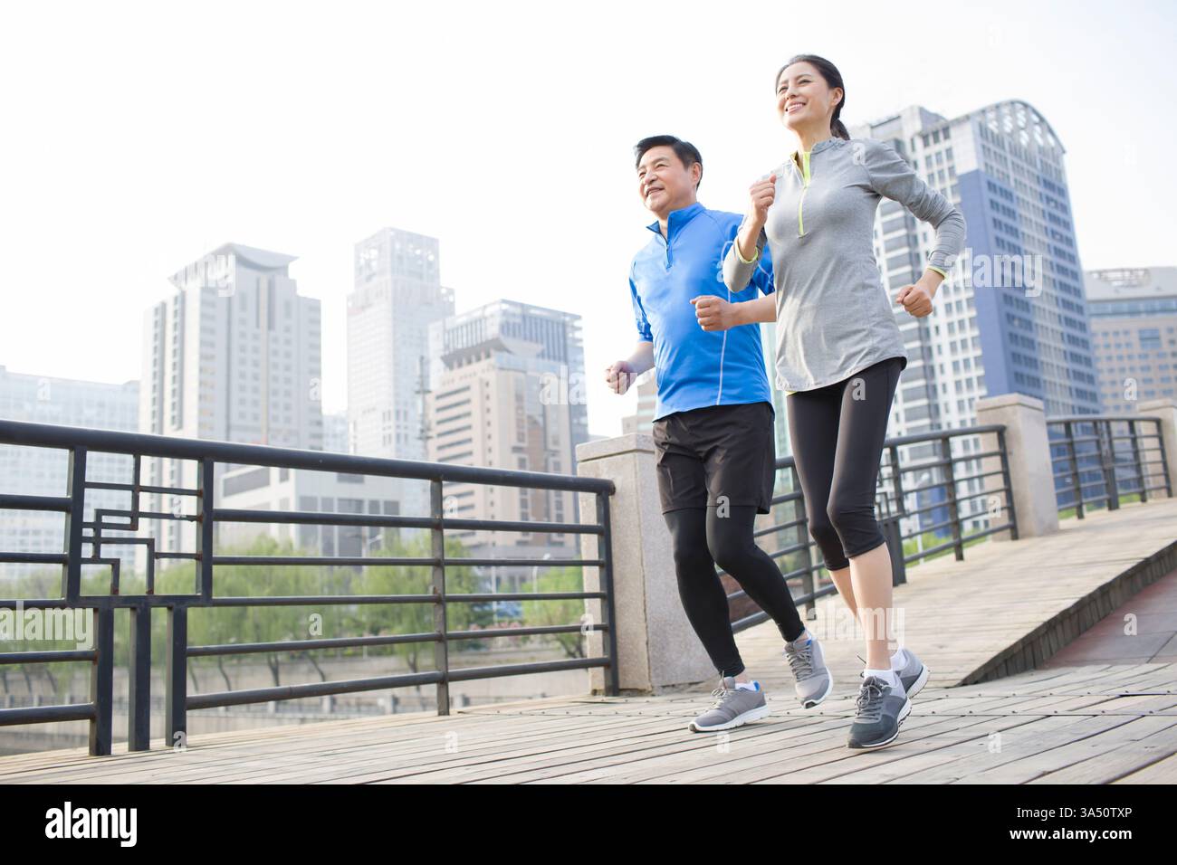 Happy mature Chinese couple running in park Stock Photo - Alamy