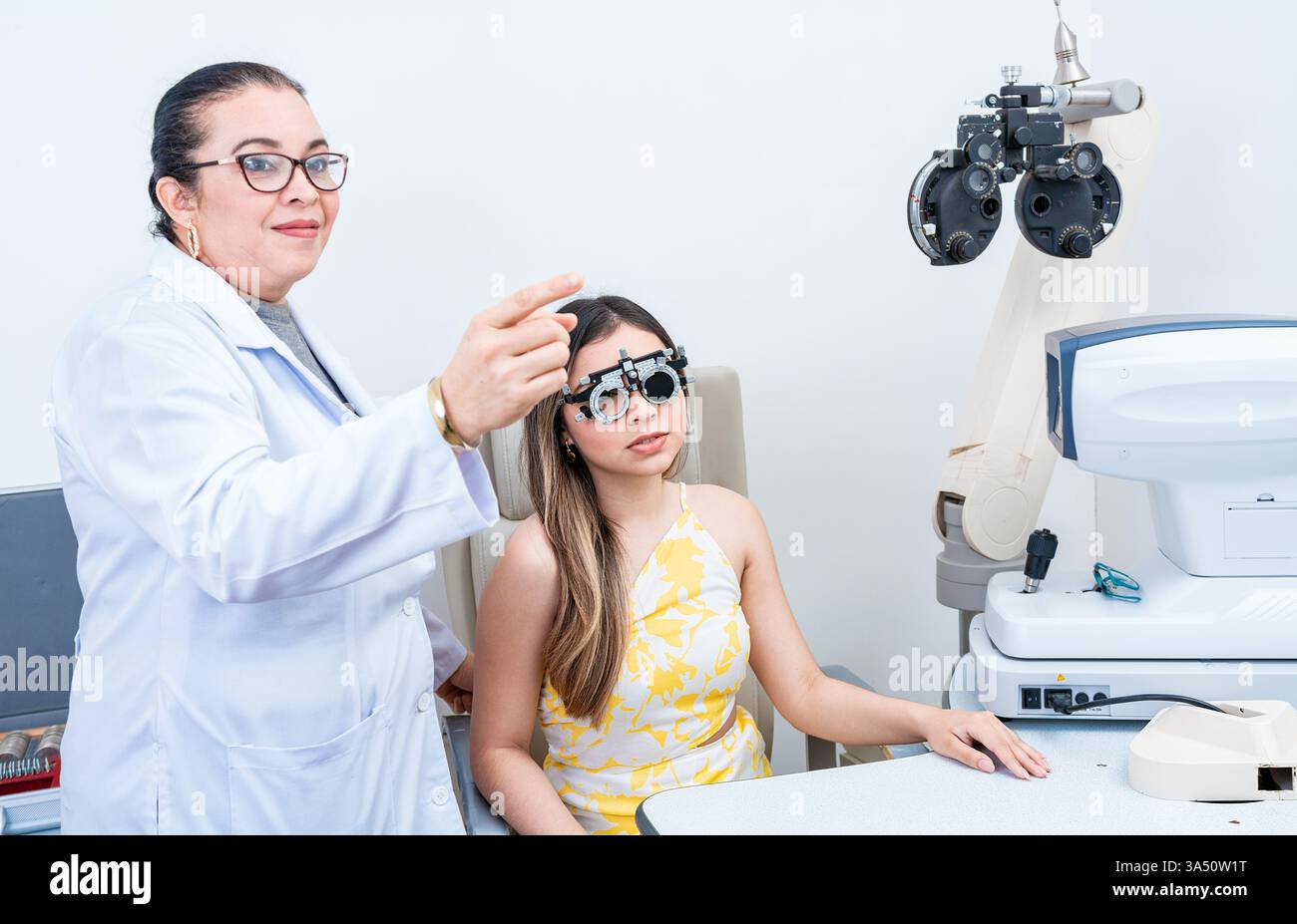 Optometrist assisting patient with optometrist trial frame. Patient ...