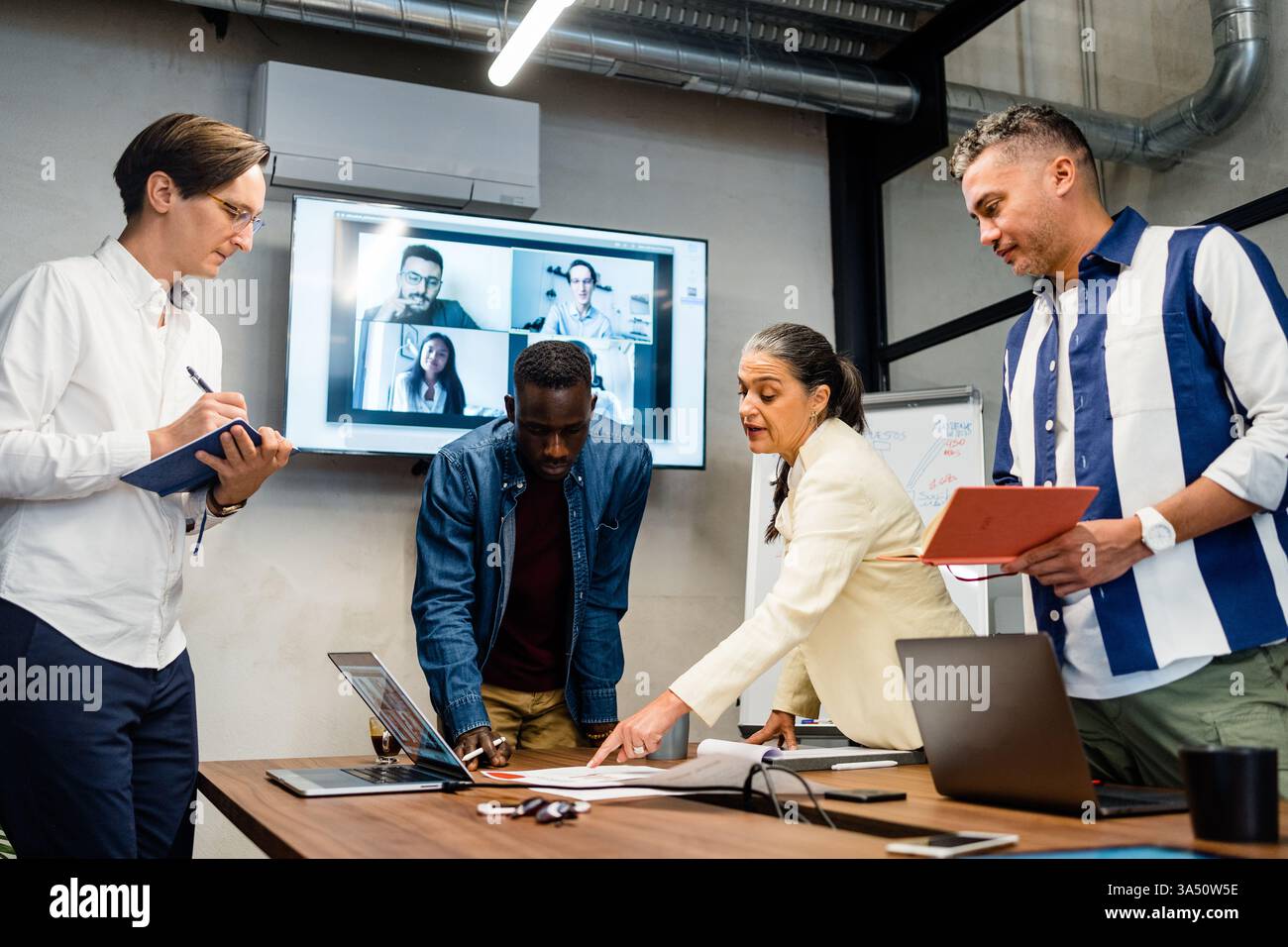 Group of business people having video conference standing near monitor ...