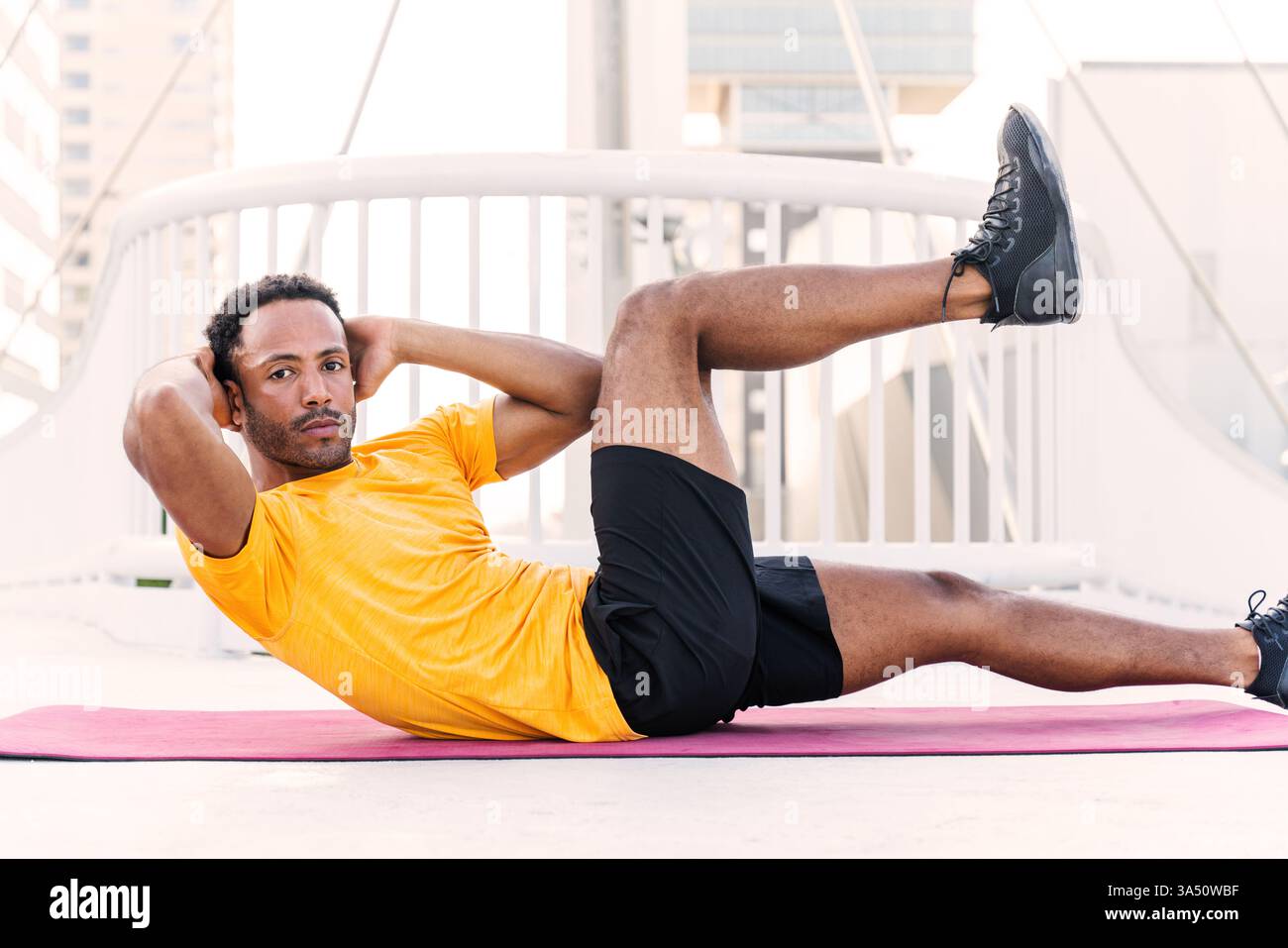 Outdoor fitness scene featuring a young Hispanic male athlete training ...